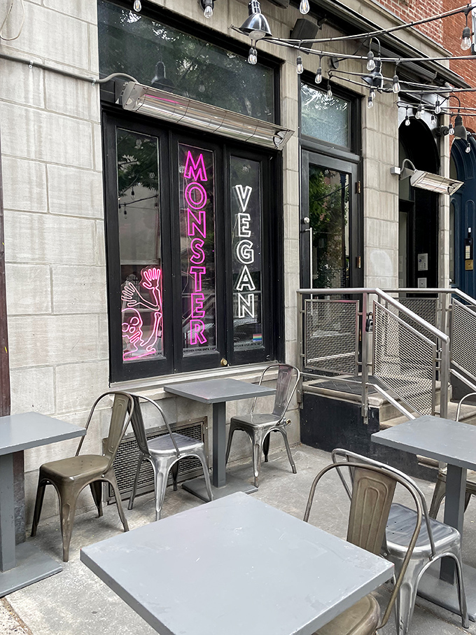 The neon-lit entrance to Monster Vegan beckons like a pink-hued beacon for the hungry and curious. Metal tables outside offer a perfect people-watching perch.