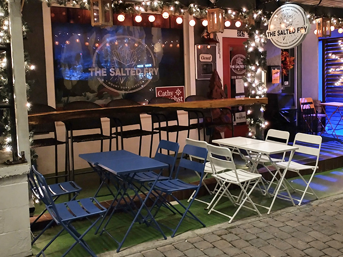 The bright orange outdoor seating at The Salted Fry beckons like a potato-loving friend, promising crispy delights behind that cheerful red door in downtown Mount Dora.