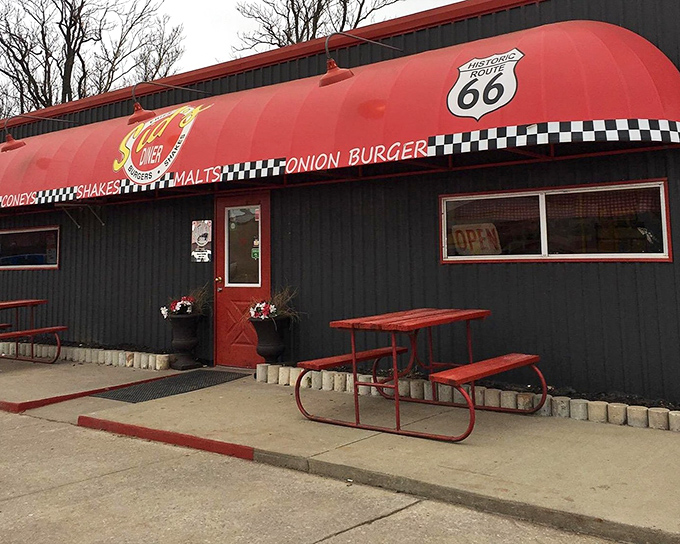 The iconic red awning of Sid's Diner beckons hungry travelers along Route 66 like a culinary lighthouse in a sea of chain restaurants.