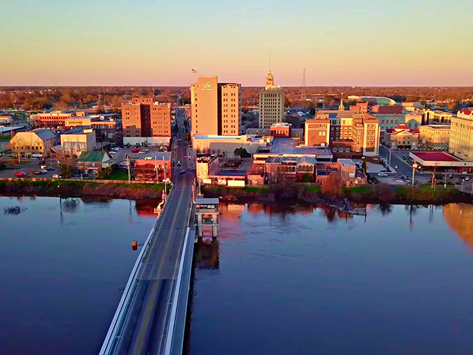 Monroe's skyline at sunset reflects in the Ouachita River like nature's own Instagram filter, showcasing the perfect blend of urban charm and natural beauty.