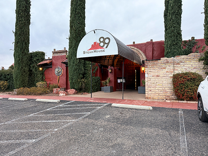 That terra cotta exterior with towering cypress trees whispers "serious steakhouse" louder than your growling stomach.