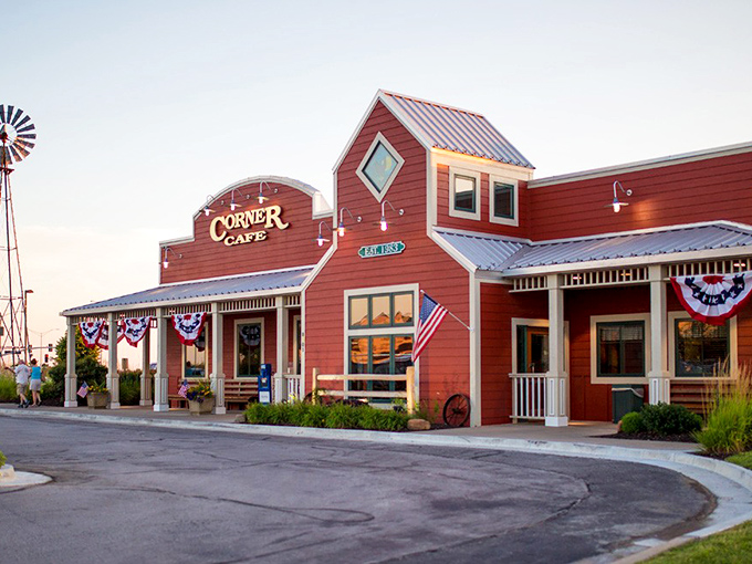 The red barn-like exterior of Corner Cafe stands proudly against the Missouri sky, complete with patriotic bunting and a welcoming porch that practically whispers, "Come on in, hungry traveler."