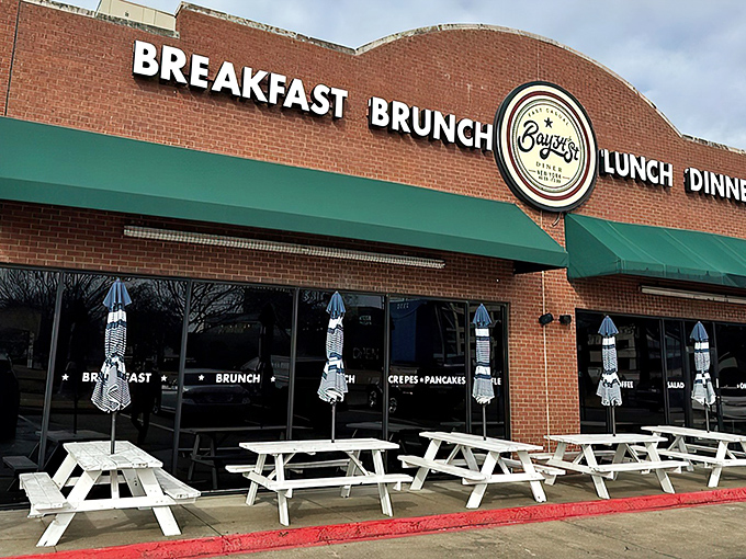 The brick facade with teal awnings isn't just inviting—it's practically shouting "Come get breakfast!" Those white picnic tables are waiting for your morning revelation.