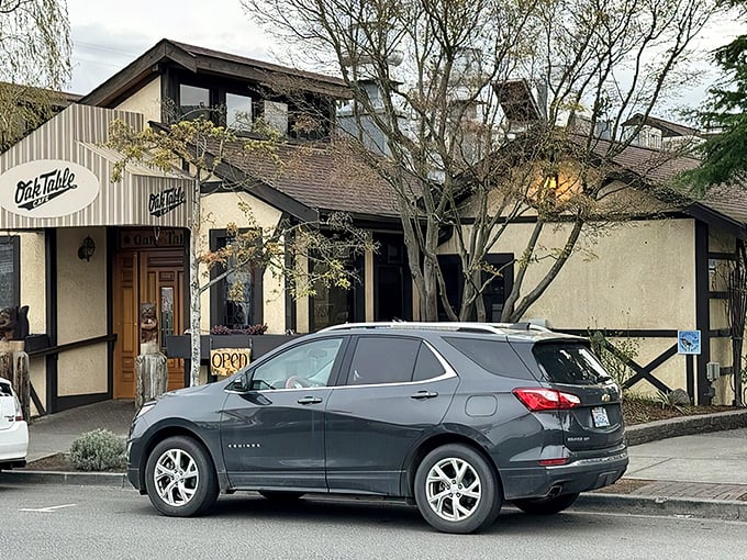 The timber-framed facade of Oak Table Cafe welcomes you like a breakfast hug. Those hanging flower baskets aren't just pretty—they're signaling that good taste awaits inside.