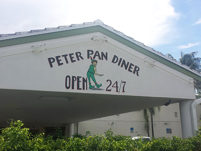 The iconic green sign beckons like a culinary lighthouse amid Florida palms. Peter Pan Diner's exterior promises comfort food magic from 6am to midnight.