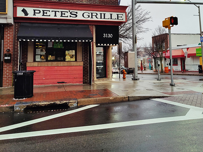 The iconic red brick corner that houses Pete's Grille stands like a beacon of breakfast hope on Greenmount Avenue, promising pancake perfection inside.