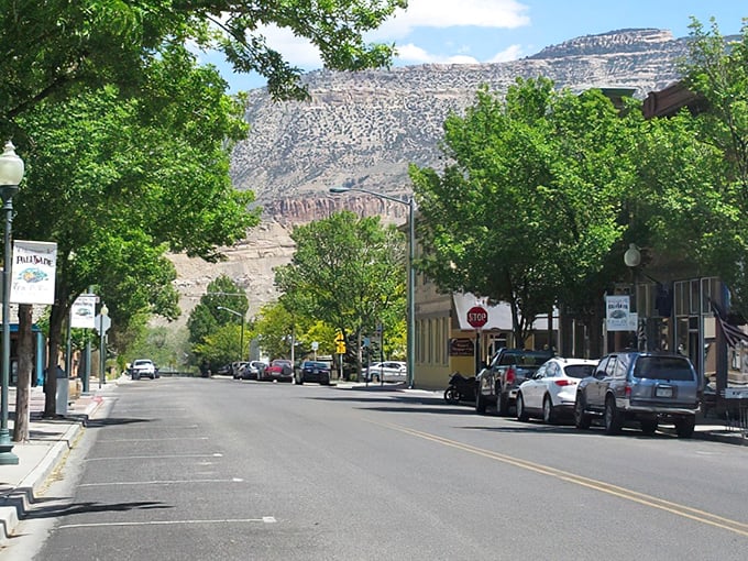 Main Street Palisade stretches toward dramatic Book Cliffs, where small-town charm meets geological grandeur in perfect Western Slope harmony.