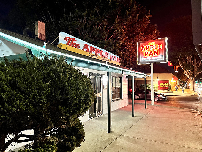The unassuming white exterior of The Apple Pan stands like a time capsule on West Pico Boulevard, its vintage sign promising "Quality Forever" – a bold claim it's managed to fulfill for decades.