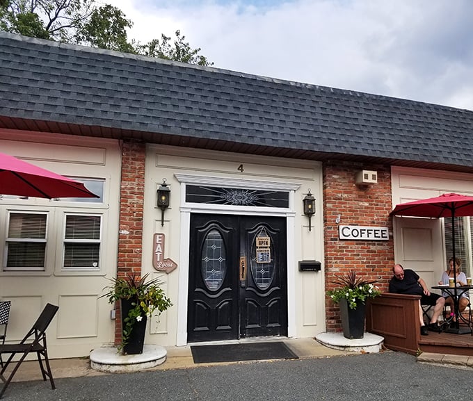 The unassuming brick exterior of Old Mill Cafe beckons with its elegant black doors and cheerful red umbrellas—like a secret breakfast society waiting to initiate you.