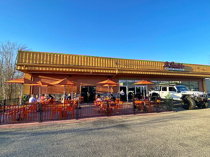 The golden glow of El Bandido's exterior promises culinary treasures within. Those red benches aren't just seating—they're the waiting room for flavor paradise.