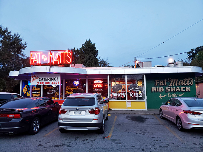The neon "FAT MATT'S" sign glows like a barbecue beacon against the twilight sky, promising smoky salvation to hungry Atlanta souls.