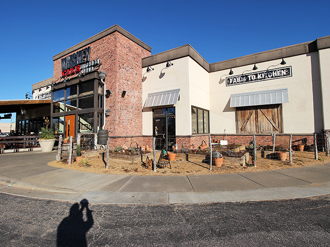 Rustic brick meets modern charm at Whiskey Cake's inviting exterior. The patio planters hint at the farm-to-table philosophy waiting inside.