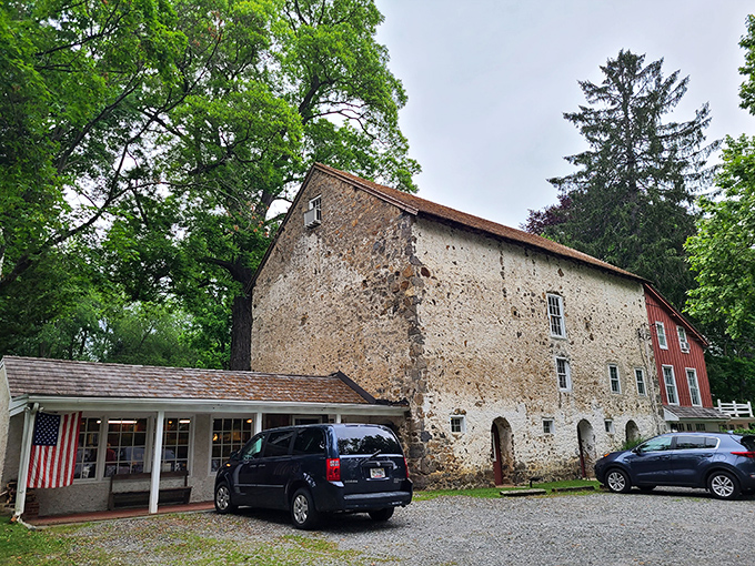The historic stone facade of Baldwin's Book Barn stands proudly among the trees, like a literary fortress guarding centuries of stories within its walls.