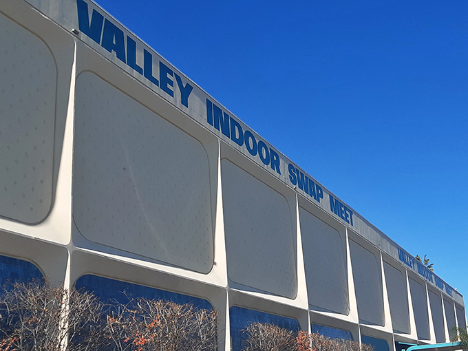 The iconic Valley Indoor Swap Meet sign stands proudly against California's endless blue sky, promising treasures within.