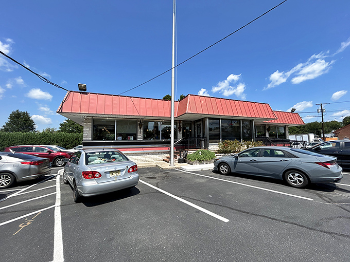 The classic red roof of Route 1 Diner stands like a beacon for hungry travelers, complete with American flag proudly waving – a true Jersey roadside landmark.