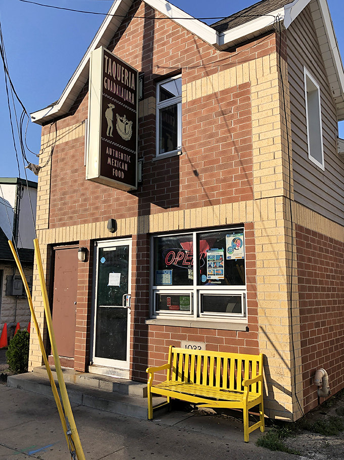 The unassuming brick exterior with that eye-catching pink bench is like a secret handshake – those who know, know this is where Madison's burrito magic happens.