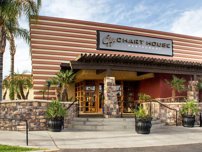 The Chart House exterior welcomes you with its distinctive horizontal stripes and stone accents—like a mid-century modern postcard that promises good times and better meals inside.