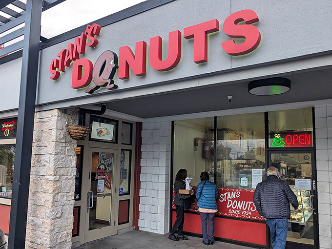 The iconic red sign of Stan's Donuts beckons like a lighthouse for the sweet-toothed sailors of Santa Clara.