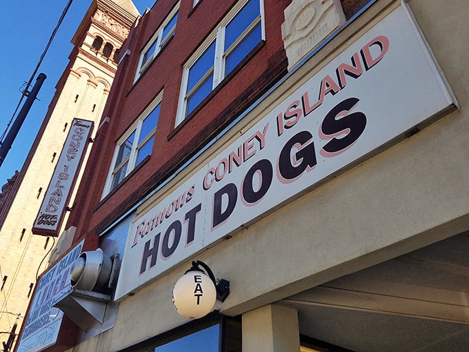 The iconic red and white sign beckons hungry travelers like a culinary lighthouse. "Famous Coney Island HOT DOGS" isn't just advertising—it's a promise kept for generations.