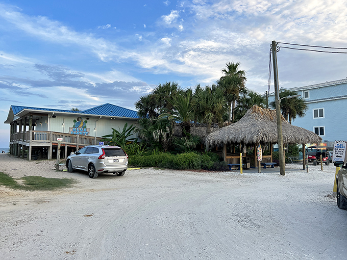 The Blue Parrot's beachfront charm beckons with its bright blue roof and thatched tiki hut—Florida architecture that practically whispers "your office emails can wait."