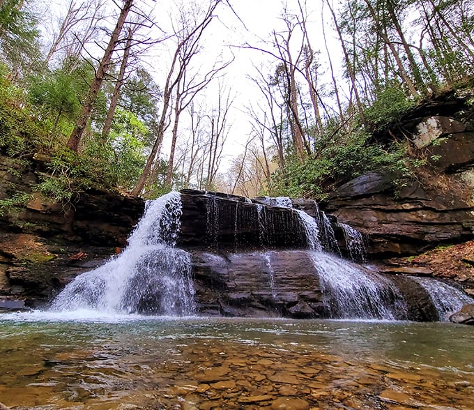Nature's perfect staircase – this waterfall at Holly River State Park cascades down rock formations like it's auditioning for a role in National Geographic.