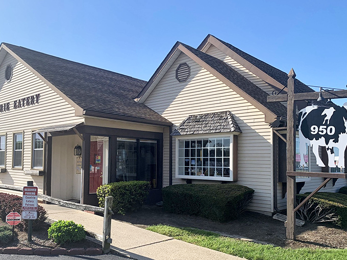 The Countrie Eatery's charming white clapboard exterior with its iconic cow sign promises comfort food paradise before you even step through the door.
