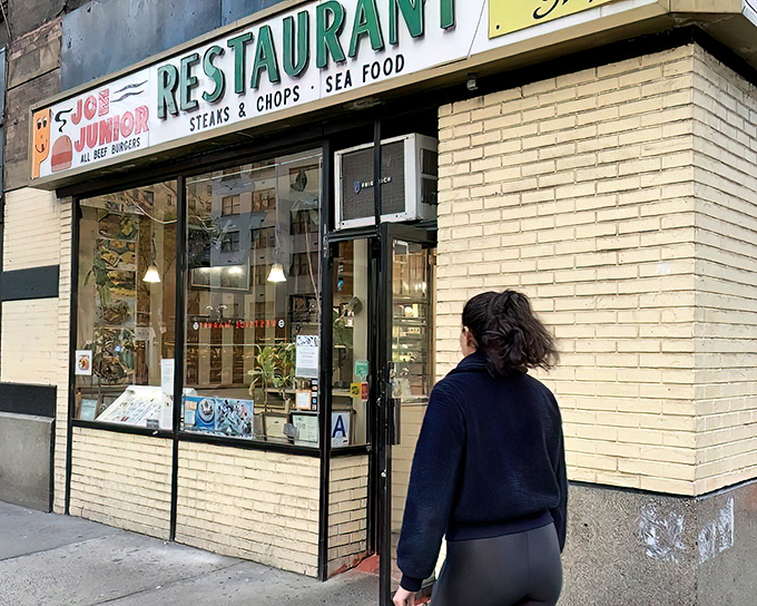 The iconic Joe Jr. sign promises three essential food groups: all-beef burgers, steaks & chops, and seafood. Classic New York diner perfection awaits inside.