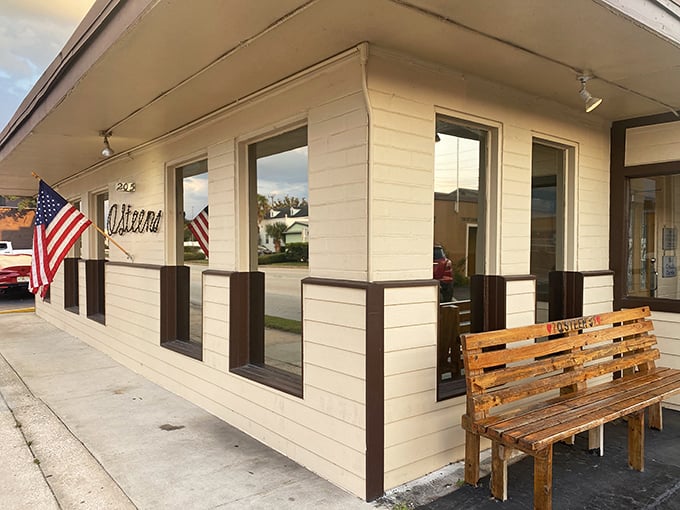 The unassuming exterior of O'Steen's, where that wooden bench isn't just seating—it's the waiting room for some of Florida's finest seafood.