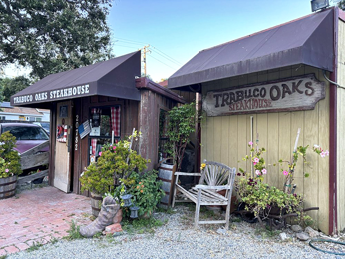 The unassuming wooden exterior of Trabuco Oaks Steakhouse promises rustic charm and serious steak business. Those barrel planters aren't just for show—they're your first hint of the no-nonsense authenticity waiting inside.
