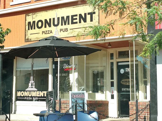 The unassuming storefront of Monument Pizza Pub beckons hungry travelers with its vintage charm and promise of pizza perfection in downtown Angola.