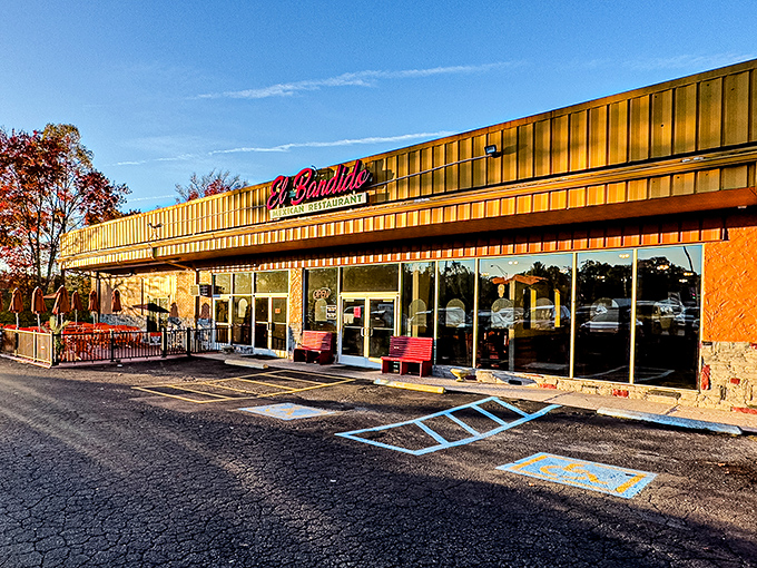 The golden glow of El Bandido's exterior promises culinary treasures within. Those red benches aren't just seating—they're the waiting room for flavor paradise.