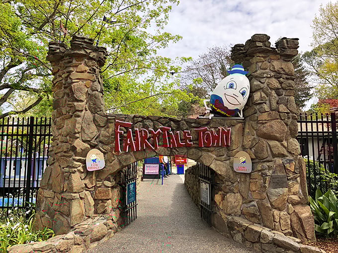 The stone archway entrance to Fairytale Town welcomes visitors with Humpty Dumpty perched above, proving some falls can lead to happy endings after all.