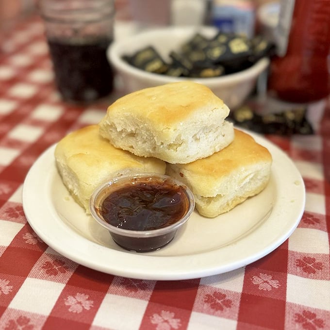 These aren't just biscuits; they're fluffy golden clouds of butter-kissed perfection. The jam alongside isn't a condiment—it's a supporting actor deserving its own award.