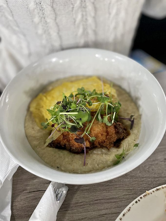 Crispy chicken nestled on a bed of creamy grits, topped with microgreens—proof that comfort food and elegance aren't mutually exclusive.