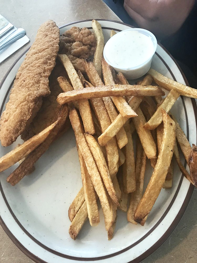 French fries so perfectly golden they deserve their own Instagram account, escorting a chicken strip that's clearly dressed for success.