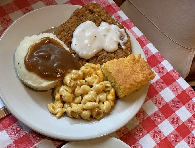 Country fried steak with white gravy, mac and cheese, and cornbread—a plate that says "you might need a nap afterward" in the most delicious way possible.