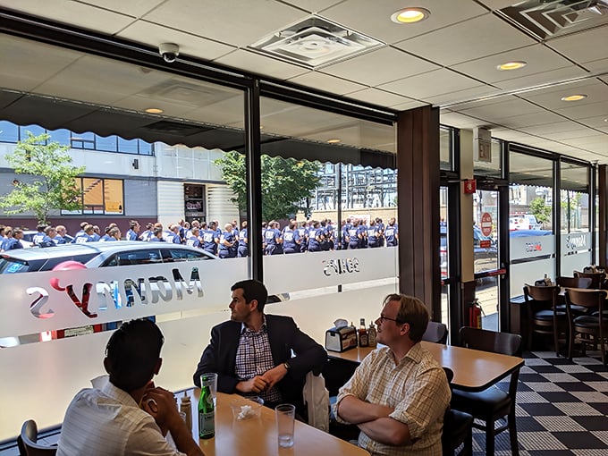 Three men sharing stories over lunch – because the best conversations happen when pastrami is on the table.