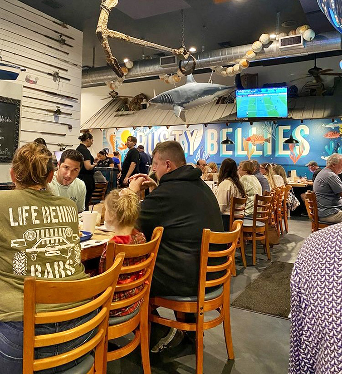 Where families gather to create memories seasoned with salt air. That shark overhead isn't just decoration—it's keeping an eye on portion control.