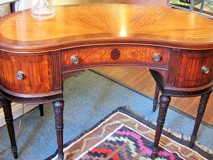 This kidney-shaped writing desk with satinwood inlay isn't just furniture—it's where someone once penned love letters long before text messages existed.