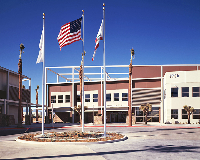 Hesperia City Hall stands as a modern desert outpost where palm trees and flags greet residents with equal enthusiasm.