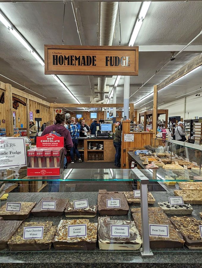 The fudge counter—where chocolate dreams are sliced into generous squares. Dark chocolate walnut, caramel, and pecan turtle tempt from behind glass.