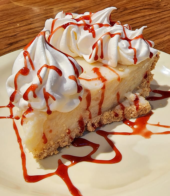 Key lime pie with whipped cream and raspberry drizzle—proof that sometimes the best things in life come on small plates with big flavors.