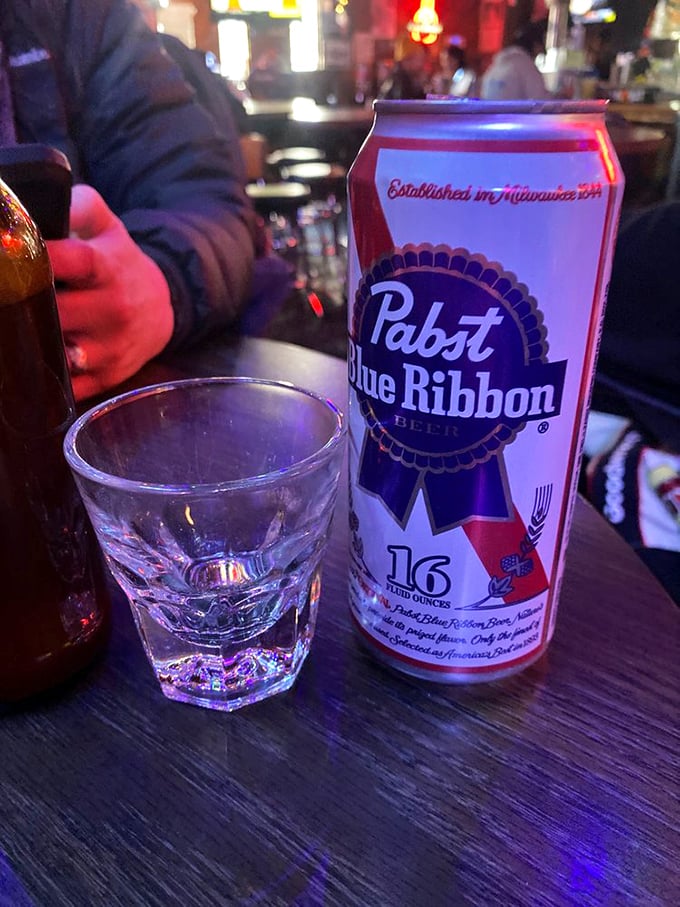 A PBR tallboy: the quintessential dive bar communion. This isn't just beer—it's liquid tradition in the temple of fried chicken.