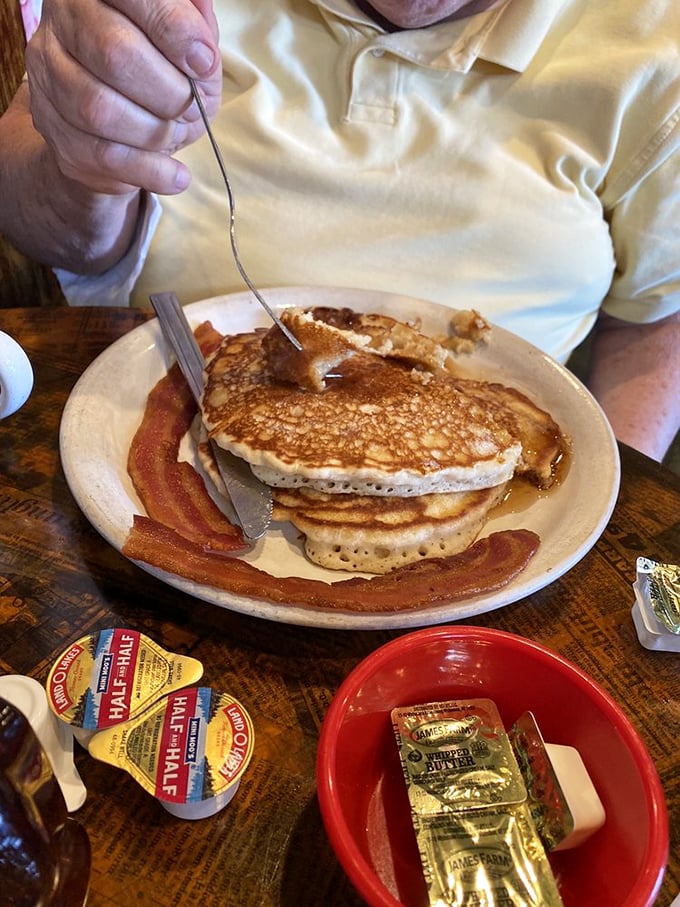 Golden pancakes with bacon strips standing at attention. Breakfast's perfect marriage of sweet and savory awaits your syrup decision.