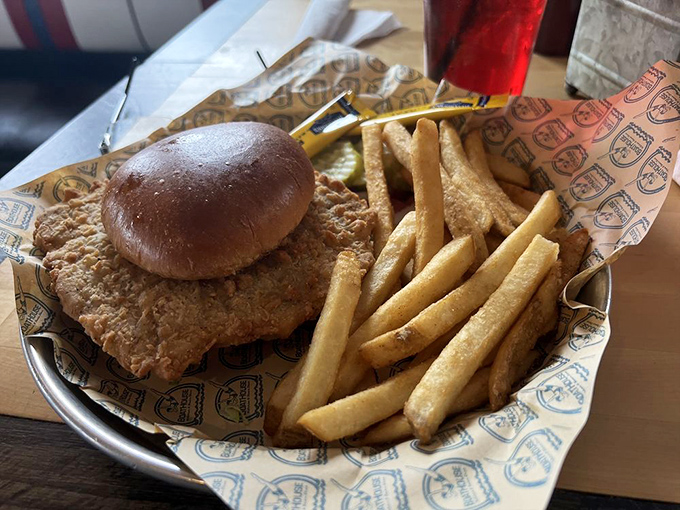 Indiana's unofficial state sandwich—the breaded pork tenderloin—served properly: comically oversized, golden-crisp, and requiring strategic first-bite planning.