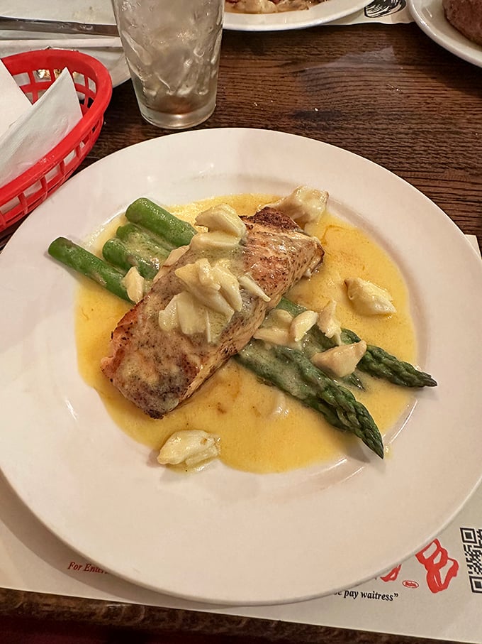 This delicate fish fillet swimming in buttery sauce with fresh asparagus isn't just dinner—it's edible poetry on a white plate.