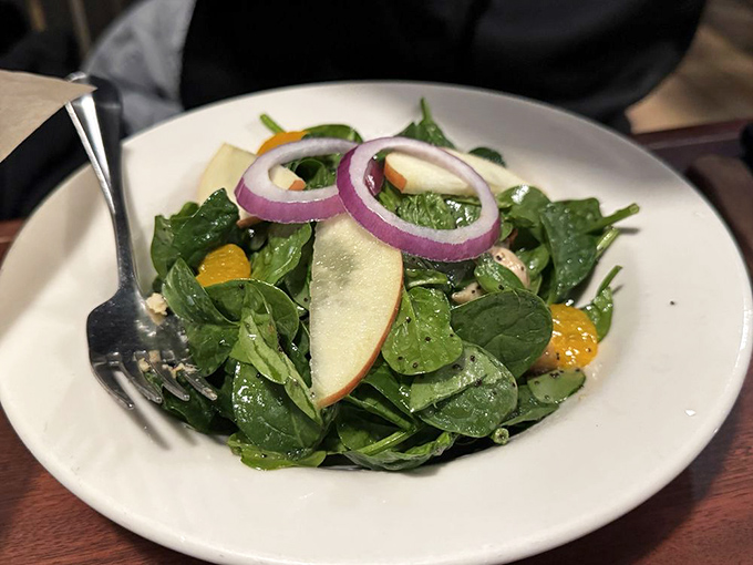 Fresh spinach salad with apple slices and red onion rings—because sometimes you need something crisp before diving into the main event.