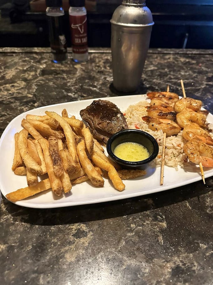 Land meets sea in perfect harmony—a tender steak alongside skewered shrimp with seasoned fries. It's the surf and turf for those who refuse to choose.