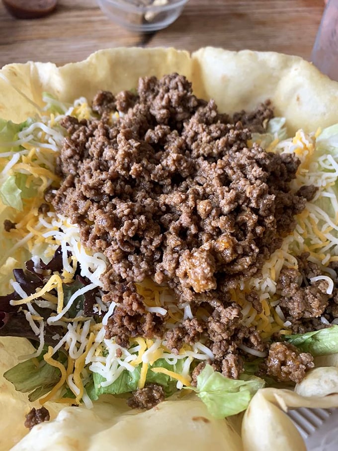 This taco salad isn't messing around – a crispy shell fortress protecting a treasure of seasoned beef, cheese, and fresh vegetables.