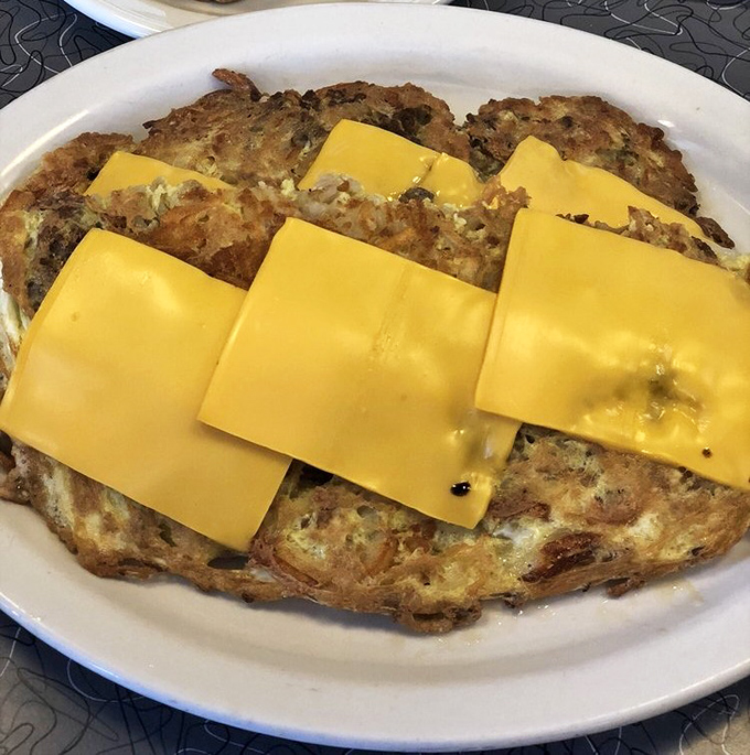 An omelet that's seen things. Those cheese slices aren't just toppings—they're yellow blankets of comfort for eggs that lived a good life.